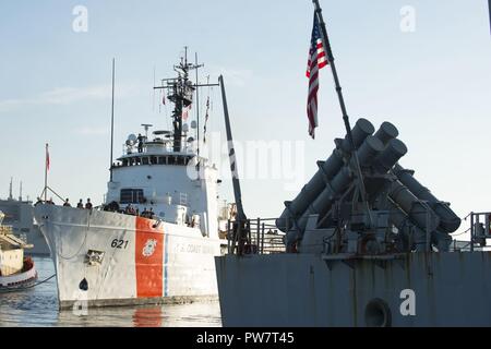 U.S. Coast Guard Cutter Valiant (WMEC-621) crew members transfer bales ...