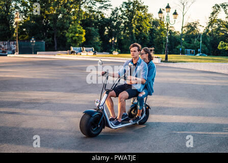 Lovely young couple driving electric bike during summer Stock Photo - Alamy