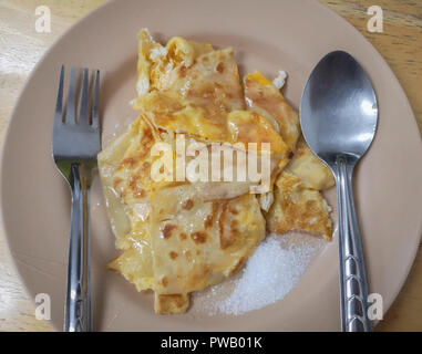 Crispy fried roti with sweetened condensed milk and sugar on paper tray ...