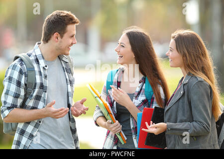 Three students talking or socializing at university campus - Friends ...