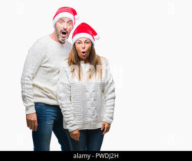 Middle age hispanic couple wearing christmas hat over isolated ...