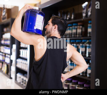 Back view of athletic sportman holding on shoulder sport nutrition in ...