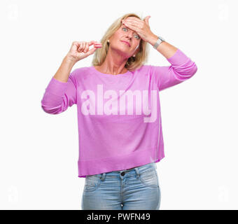 Middle age blonde woman eatin pink macaron biscuit over isolated ...