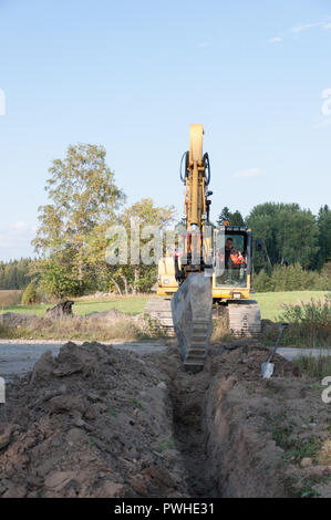 Digger laying underground electric cables Stock Photo - Alamy
