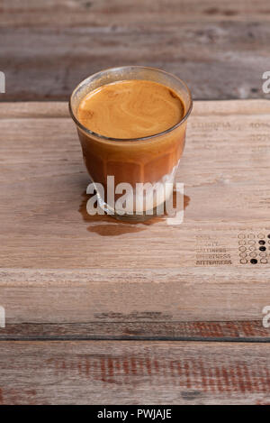 Closeup shot of a glass of iced coffee and biscuits with jam on a table ...