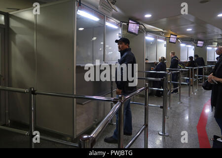 Passengers pass through passport control desks at the arrival hall of ...