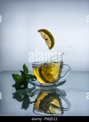 A green glass cup with a splash of liquid Stock Photo - Alamy
