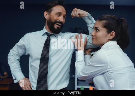 Business people showing muscles in office Stock Photo - Alamy