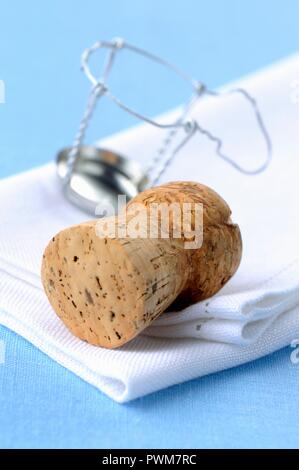 sparkling wine cork inside a wire cage isolated on a black background ...
