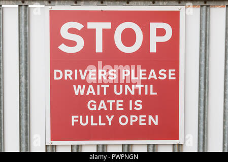 STOP drivers please wait until gate is fully open sign Stock Photo - Alamy