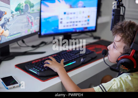 Boy playing Fortnite game. Fortnite is online video game developed by ...