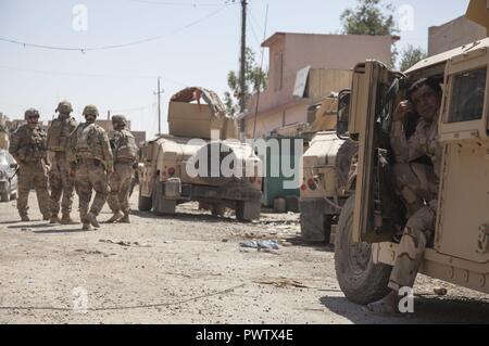 US Navy Iraqi soldier sits and watches a U.S. Army patrol drive by in ...