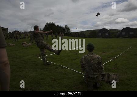 A British soldier participates in a boot toss as part of a team ...