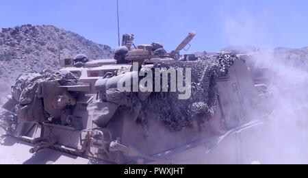US soldiers use a tank recovery vehicle to load a mine plow for a M1A1 ...
