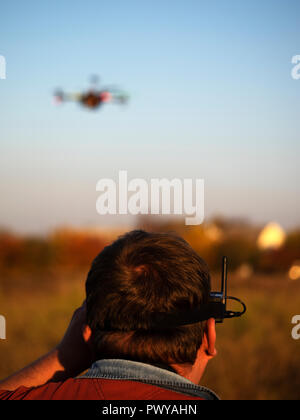 Man seen operating a drone with remote control Stock Photo - Alamy