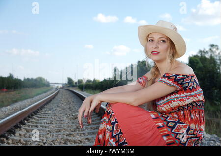 an amazing young blonde lady wait to locomotive, try stop train Stock ...