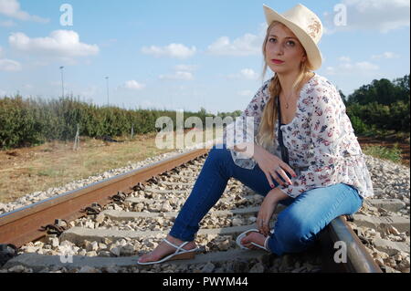 an amazing young blonde lady wait to locomotive, try stop train Stock ...