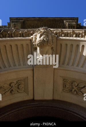 Ribbed stone arch with grotesque head of plutus keystone in old bank ...