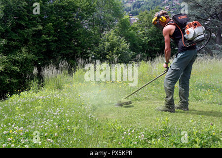 Gardner cutting grass verge with brushcutter. France Stock Photo - Alamy