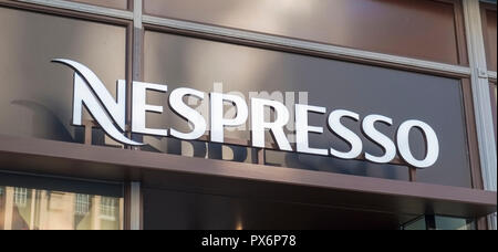 Close-up of Nespresso logo sign mounted on stone building facade under ...