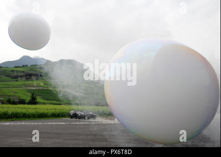 Switzerland, Wallis, artificial white air bubbles from bubble machine ...