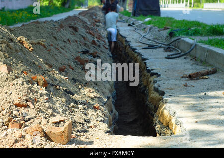 Road workers digging hole on street, St.Jude's Road, Englefield Stock ...