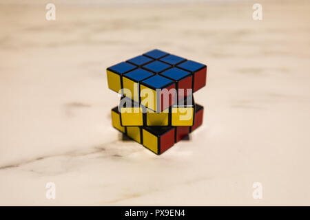 Rubik's Cube on a marble plate, showing green, yellow and red closeup ...