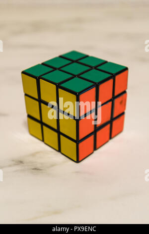 Rubik's Cube on a marble plate, showing green, yellow and red closeup ...