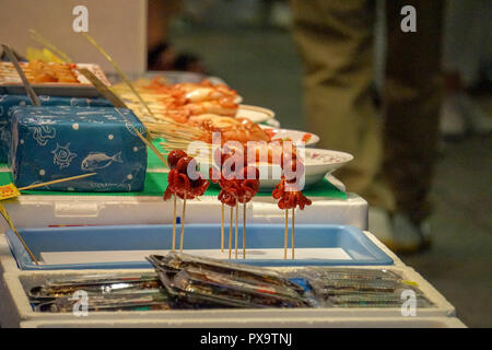 Delicious grilled baby octopus skewer street food stall with appetizing ...