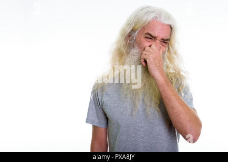 Studio shot of disgusted senior bearded man looking and pointing to the ...