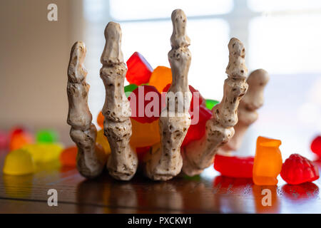Skeleton hand with bowl of Candy during halloween Stock Photo - Alamy