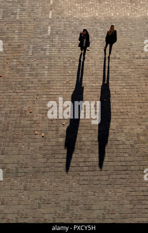 People cast long shadows on walls as they commute in Glasgow. Picture ...