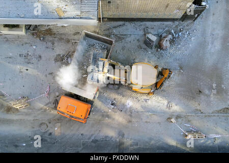 Bulldozer loader uploading waste and debris into dump truck at ...