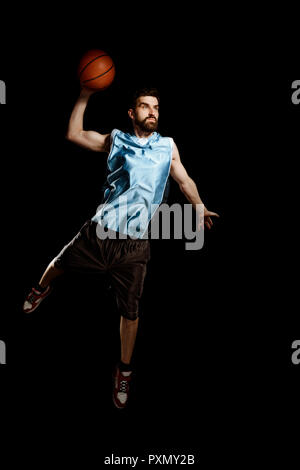 Basketball player making a jump shot against blue sky background Stock ...