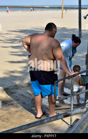 Washing sand from beach off feet Stock Photo - Alamy
