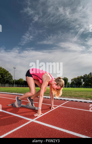Female runner in starting position, panoramic view, phases Stock Photo ...