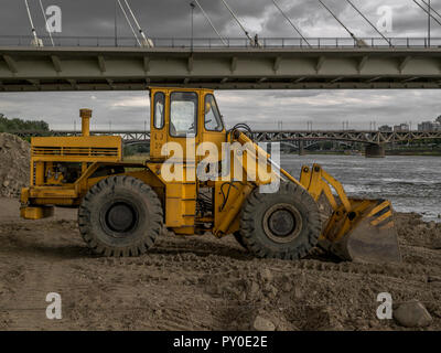 A yellow bulldozer next to a bridge Stock Photo - Alamy