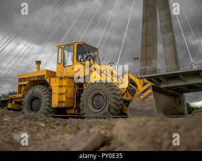 A yellow bulldozer next to a bridge Stock Photo - Alamy