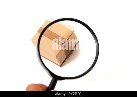 magnifying glass inspecting a cardboard box isolated over a white ...