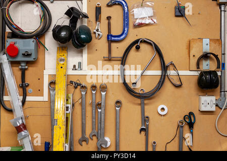 Garage tool rack with various tools and repair supplies on board and ...