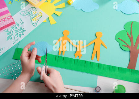Child cutting colored paper with scissors at the table Stock Photo - Alamy