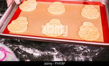 Unbaked sugar skull cookies on baking sheet for Dia de los Muertos ...