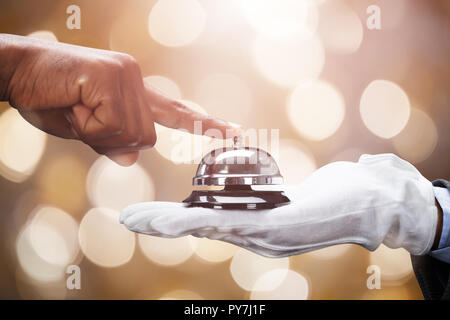 Customer's Hand Ringing Service Bell Held By Waiter On White Background ...