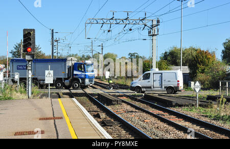 Vehicles traverse the level crossing at Ely railway station ...