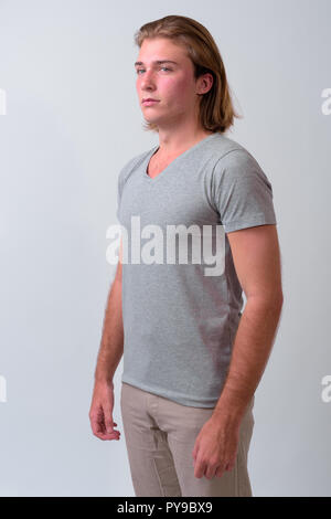 Profile portrait of pensive handsome blonde little boy in gray T-shirt ...