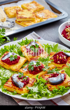 Baked polenta cheese bars topped with pistachio nuts and Parmesan Stock ...