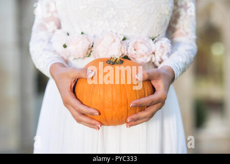 Halloween Bride holding pumpkin in her hands Stock Photo - Alamy
