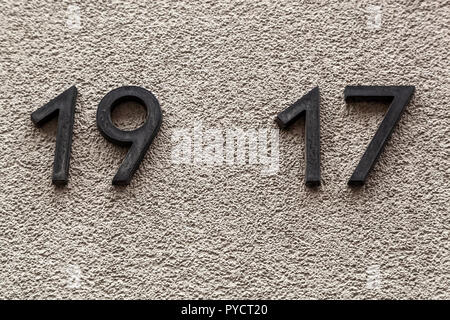 House number nineteen 19 painted black on yellow render in stylised ...