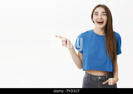 Portrait of enthusiastic young woman reacting amazed and surprised at ...