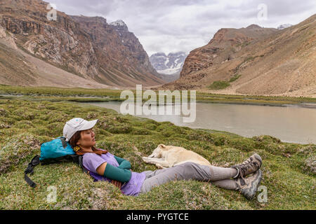 Trekker naps with local dog in Engels Peak Meadows, Langar, Tajik ...